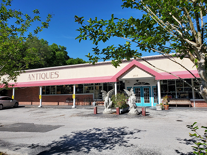 The pink awning practically winks at you from the roadside, with angel statues standing guard like bouncers at the gates of vintage heaven.