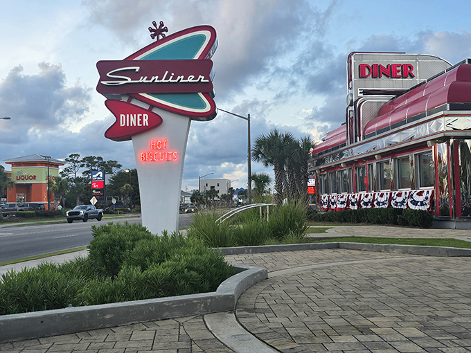 That neon sign isn't just announcing a diner—it's broadcasting a time machine. The Sunliner's atomic-age design practically begs you to dust off your saddle shoes.