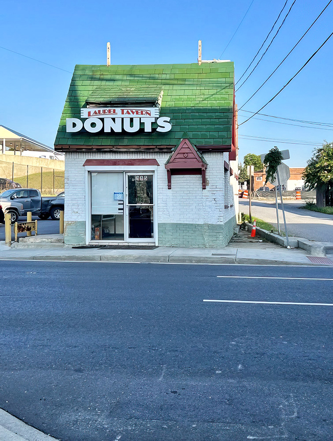The little green-roofed donut house stands like a storybook cottage, beckoning hungry travelers with its siren call of fried dough.
