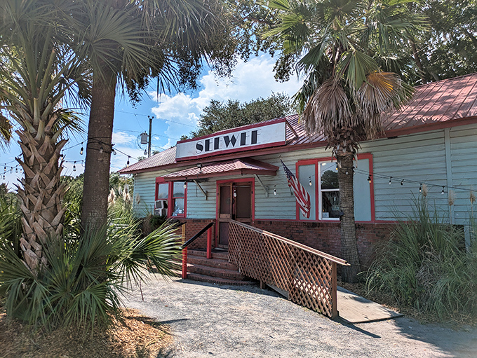 The light blue exterior with red trim stands like a coastal sentinel among the palmettos, promising seafood treasures within. No fancy facade needed when the food speaks volumes.