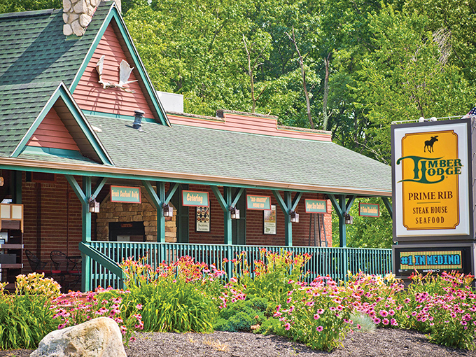 Summer brings a burst of color to Timber Lodge's exterior, where vibrant flowers frame this woodland retreat like nature's own welcome mat.