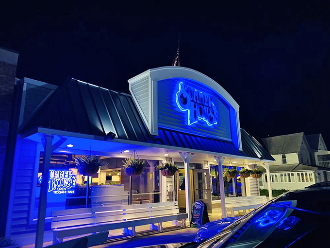 The iconic blue Summer House sign glows like a beacon in the night, promising culinary treasures within this Rehoboth Beach landmark.