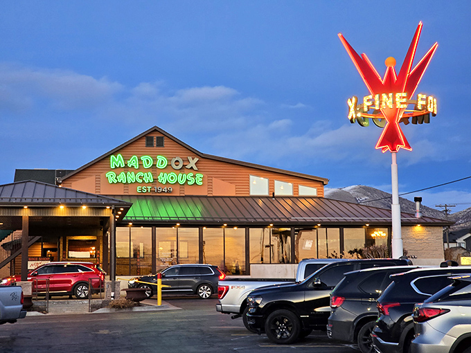 The neon cowboy sign at Maddox Ranch House glows like a beacon for hungry travelers, promising carnivorous delights within those wooden walls.