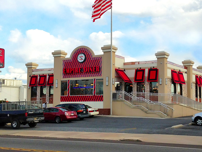 The New Empire Diner stands proud with its classic American architecture, bold red awnings, and an American flag that practically screams "good food happens here!"