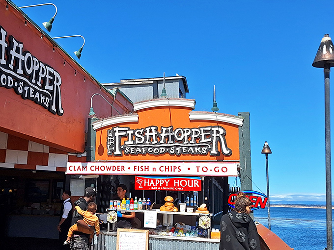 The vibrant orange facade of Fish Hopper stands like a cheerful sentinel on Cannery Row, promising seafood treasures with a side of breathtaking ocean views.