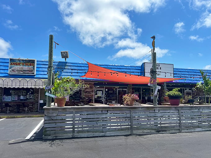 The blue building with its vibrant orange awning stands out against the Florida sky like a beacon for sandwich lovers. Angie's Subs isn't hiding from anyone.