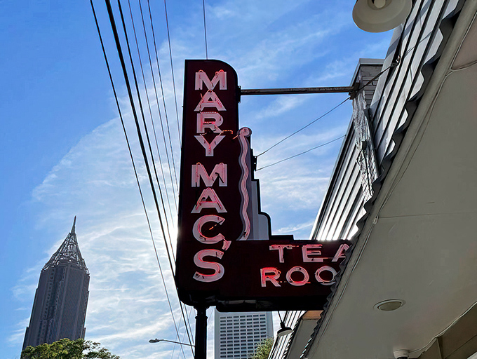 The iconic neon sign of Mary Mac's Tea Room stands as a beacon of Southern comfort against Atlanta's skyline &ndash; a promise of culinary magic within.