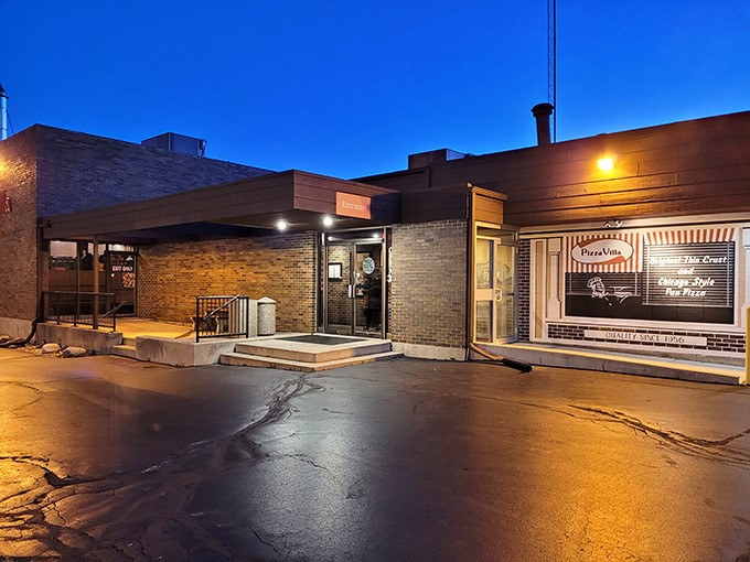 As twilight descends, Pizza Villa's modest entrance transforms into a beacon for hungry souls seeking authentic pizza perfection in DeKalb.