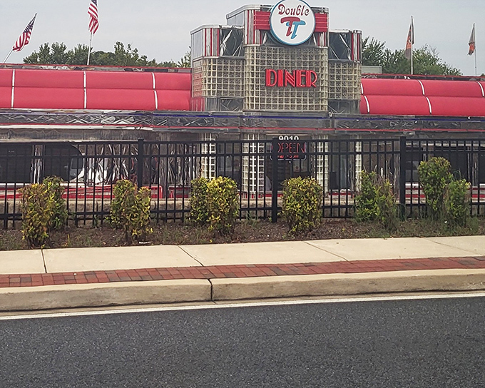 The gleaming stainless steel exterior of Double T Diner catches Maryland sunlight like a time machine to the 1950s, complete with signature red trim and glass blocks.