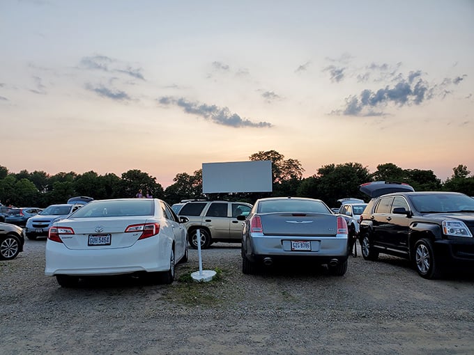 Cars lined up at twilight, a sea of anticipation as the massive screen awaits its moment to shine against an Ohio sunset.