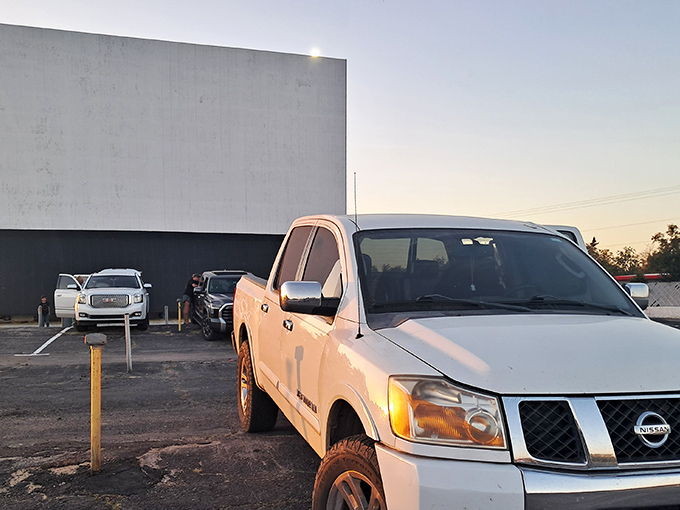 The massive white screen awaits dusk's embrace, when pixels will dance across its surface and transform an ordinary parking lot into movie magic.