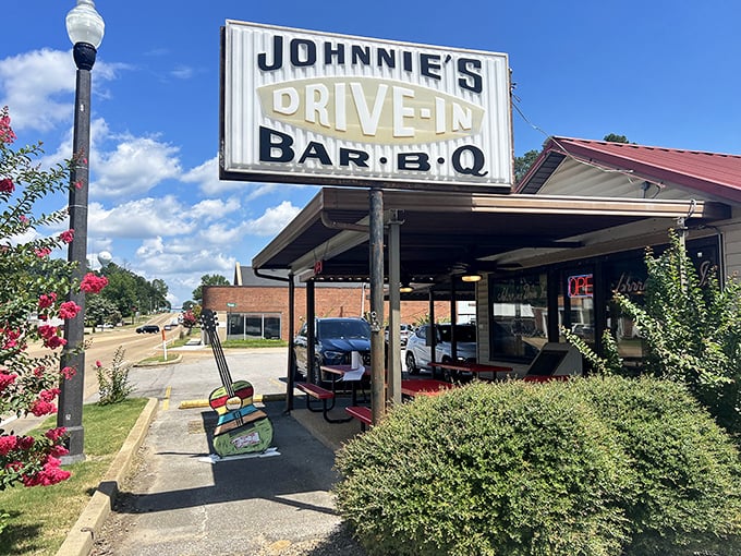 The iconic Johnnie's Drive-In sign stands proud against the Mississippi sky, a beacon of culinary nostalgia that's been drawing hungry pilgrims for generations.