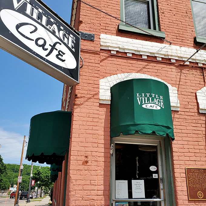 The coral-brick facade with emerald awnings isn't just charming&mdash;it's a beacon for hungry travelers. This corner of Baraboo promises culinary surprises behind that vintage sign.