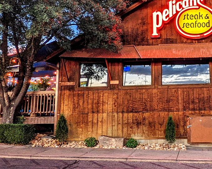 The rustic wooden exterior of Pelican's glows at dusk, a maritime mirage in the desert that promises oceanic treasures within.