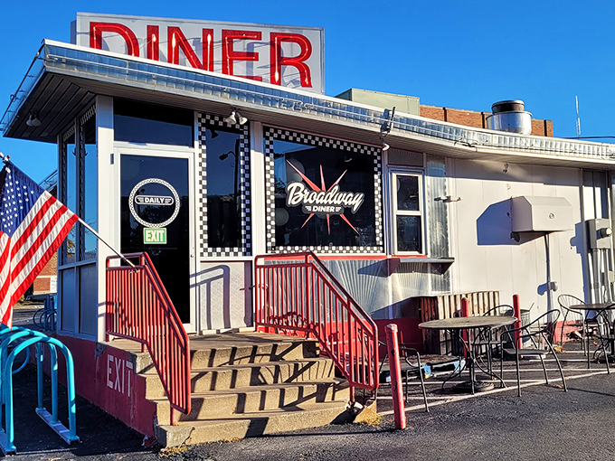 The iconic red "DINER" sign beckons hungry travelers like a lighthouse for the breakfast-starved. Classic Americana at its finest.