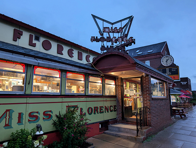The iconic neon sign of Miss Florence Diner glows at dusk, beckoning hungry travelers to this authentic Massachusetts time capsule.