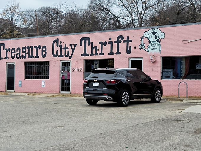 The bubblegum pink exterior of Treasure City Thrift stands out like a flamingo at a penguin convention, complete with their cartoon mascot promising "Spending That Money."