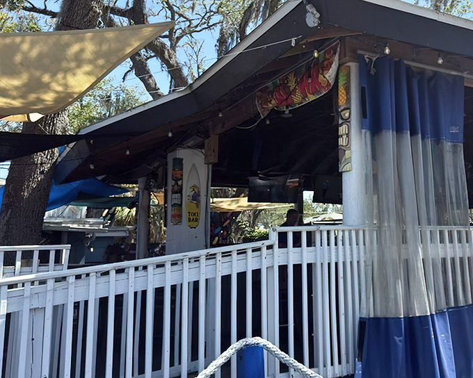 The outdoor patio beckons with its casual charm, where shade sails and white railings create the perfect Florida escape from reality.
