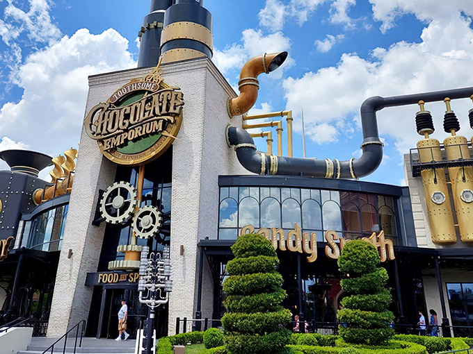 The façade screams "mad scientist's chocolate laboratory" with its gleaming pipes and industrial elegance. Even the topiary has a perfectly manicured Victorian sensibility.