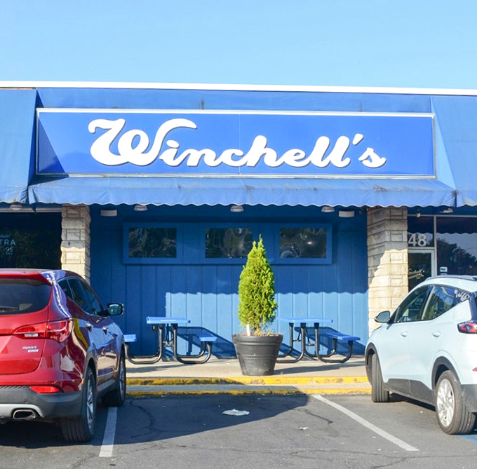 That signature Winchell's blue continues right to the entrance, where a touch of greenery welcomes diners. The picnic tables hint at casual comfort&mdash;exactly what you want before diving into that famous buffalo chicken sandwich.