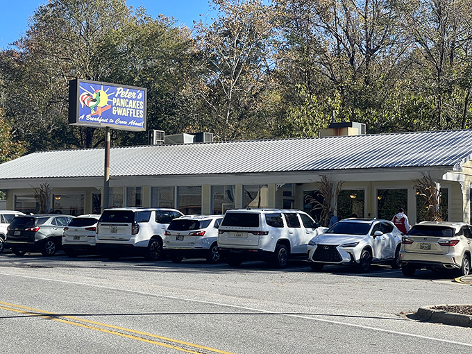 The cheerful yellow sign beckons hungry travelers like a breakfast lighthouse. Peter's Pancakes & Waffles promises "A Breakfast to Crow About" against the backdrop of Cherokee's lush mountains.