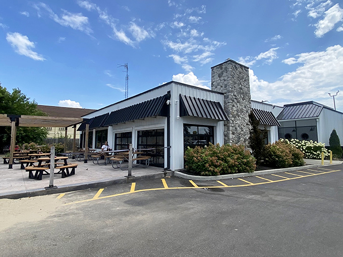 Black awnings and a stone chimney frame this lakeside gem, where picnic tables promise casual dining with a side of fresh lake breeze.
