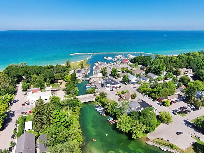 A bird's-eye view of Leland reveals its perfect positioning between Lake Michigan's turquoise waters and the lush greenery of the peninsula.