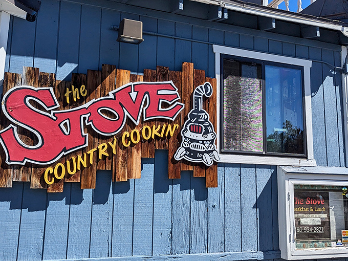 The blue exterior of The Stove announces itself with no pretension—just a bold promise of "COUNTRY COOKIN'" that's been keeping mountain visitors happily fed for generations.