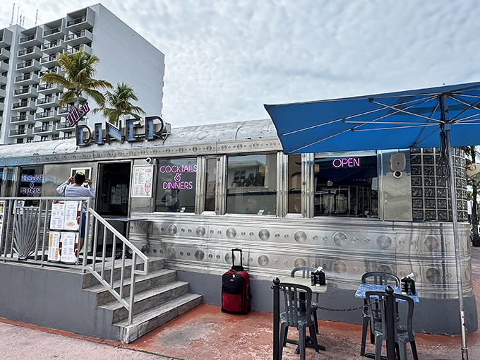 The gleaming silver exterior of 11th Street Diner stands like a time machine in Miami Beach, beckoning hungry time travelers with its classic Art Deco charm.