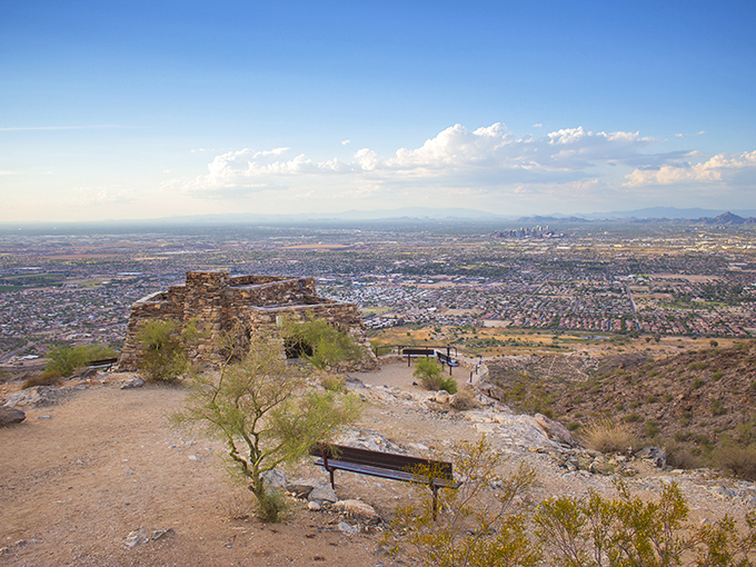 The stone ramada at Dobbins Lookout stands like a desert sentinel, offering shade and spectacular views that make Phoenix look like a miniature model city.