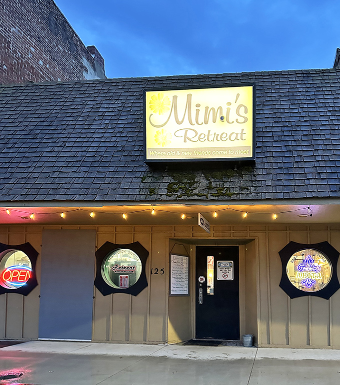 The unassuming exterior of Mimi's Retreat beckons with its glowing sign and porthole windows&mdash;proof that culinary treasures often hide in plain sight.