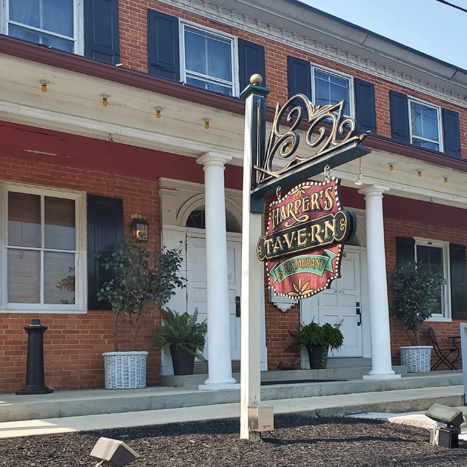 The iconic red brick fa&ccedil;ade of Harper's Tavern stands as a culinary lighthouse in Annville, beckoning hungry travelers with its vintage neon sign promising good times and better meals.