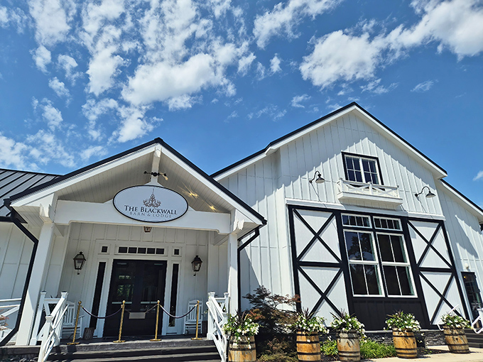 Approaching the entrance feels like discovering a secret culinary hideaway, where rustic charm meets upscale dining under picture-perfect blue skies.