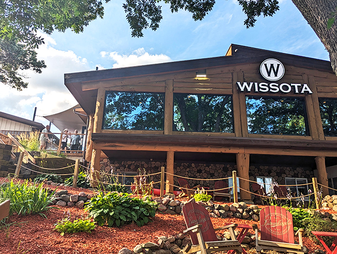 Rustic charm meets lakeside elegance at Wissota High Shores, where those red Adirondack chairs practically whisper, "Sit down, stay awhile."