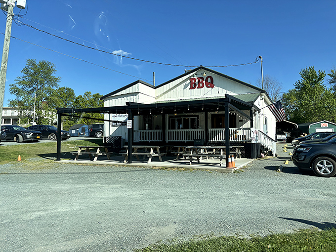 The white clapboard exterior with its simple "BBQ" sign isn't trying to impress you. The smoke wafting from behind the building is doing that job perfectly.