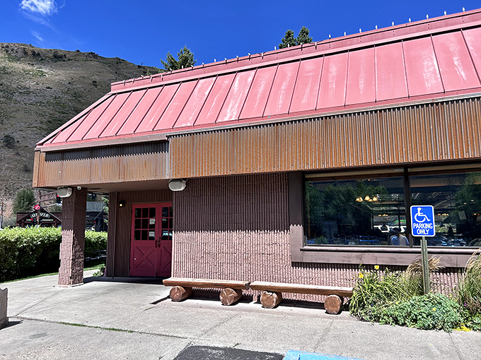 The rustic exterior with its weathered wood and red door promises authentic Western hospitality before you even step inside.