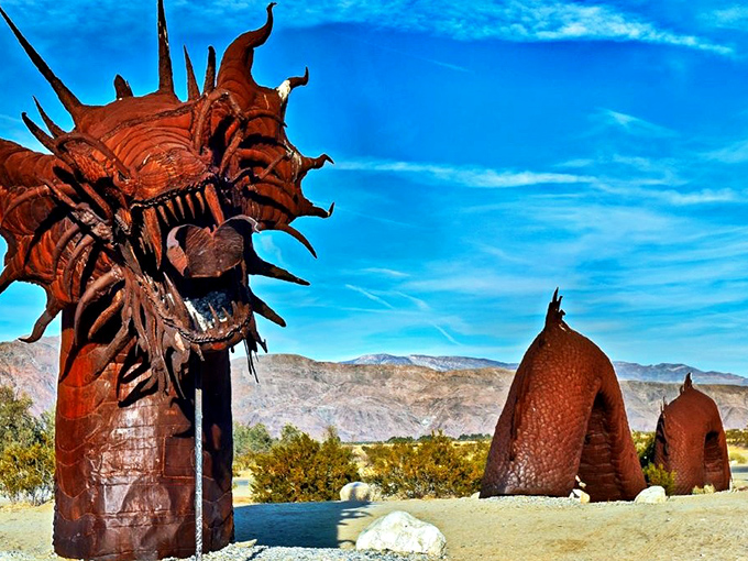 The fearsome dragon rises from the desert floor, its spiky metal head and undulating body segments creating an otherworldly silhouette against Borrego's brilliant blue sky.