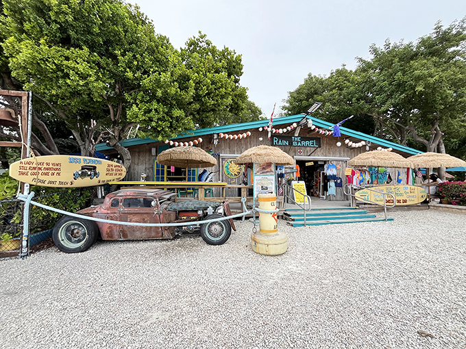 A vintage car and thatched umbrellas welcome you to Rain Barrel Village, where Florida Keys quirkiness meets artistic charm in a gravel paradise.