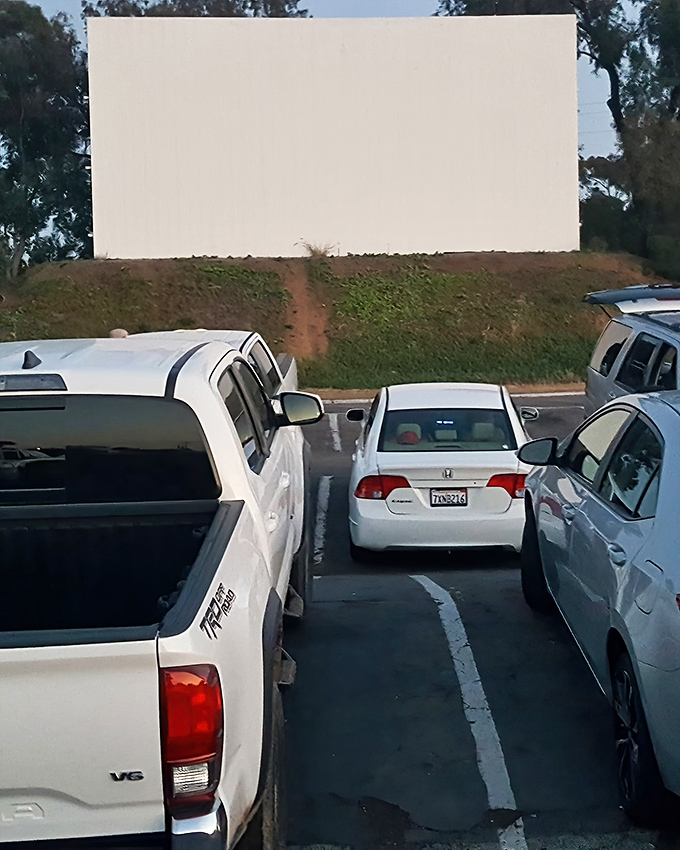 The iconic white screen of South Bay Drive-In stands ready for dusk, when movie magic transforms this simple structure into a portal to other worlds.
