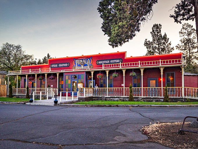 The Wild West meets culinary excellence at Tumalo Feed Company's iconic red exterior. Those hanging flower baskets aren't just for show&mdash;they're welcoming you to steak paradise.