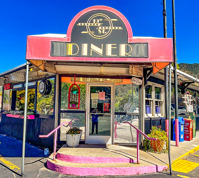 The iconic pink awning of 19th St. Diner stands out like a beacon of breakfast hope against Colorado's mountain backdrop. Resistance is futile.