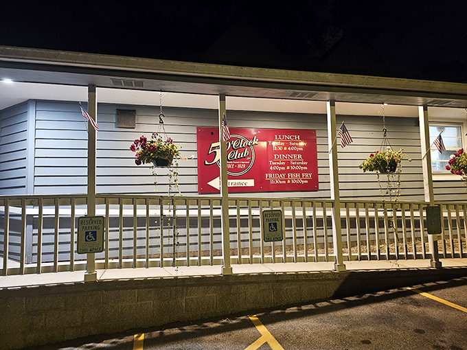 Nighttime transforms this lakeside tavern into a beacon for hungry travelers, with hanging flower baskets adding a touch of warmth to its no-nonsense appeal.