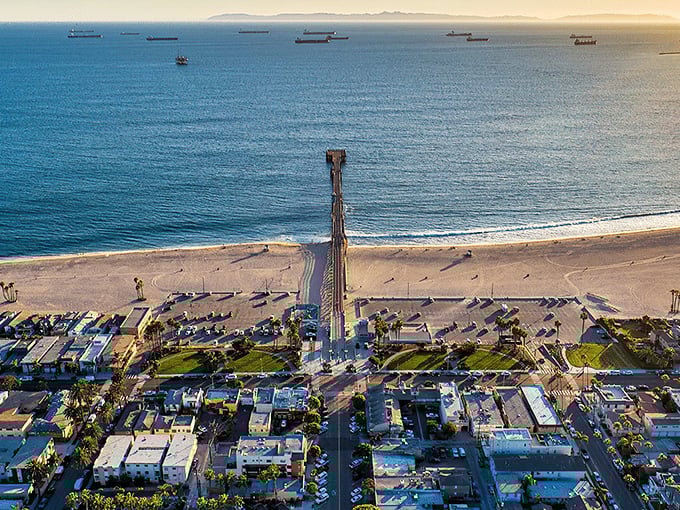 The perfect California postcard comes to life where Seal Beach's golden shoreline meets the Pacific, with cargo ships dotting the horizon like patient sentinels.