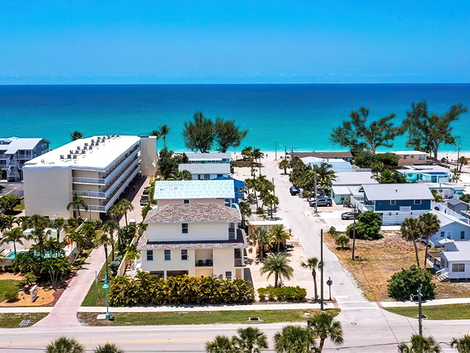 Aerial paradise where retirement dreams come true &ndash; pastel homes nestled between palm trees with the turquoise Gulf of Mexico stretching endlessly beyond. Old Florida charm meets affordable coastal living.