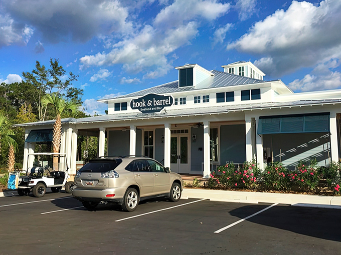 A second view of Hook & Barrel's inviting facade, where palm trees stand guard and flowering shrubs add splashes of color to this seafood sanctuary.