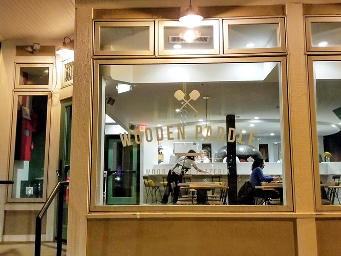 The storefront beckons with understated elegance, those crossed wooden paddles in the window promising pizza nirvana within Lemont's charming downtown.