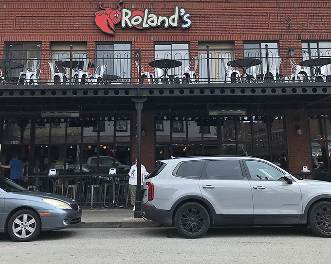 The brick facade of Roland's welcomes seafood pilgrims with its cheerful lobster mascot, promising maritime delights in Pittsburgh's historic Strip District.