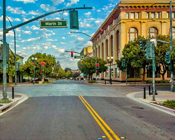 Downtown Vallejo's historic architecture gleams in golden sunlight, where tree-lined streets and vintage buildings create a postcard-perfect scene that whispers "affordable retirement paradise."
