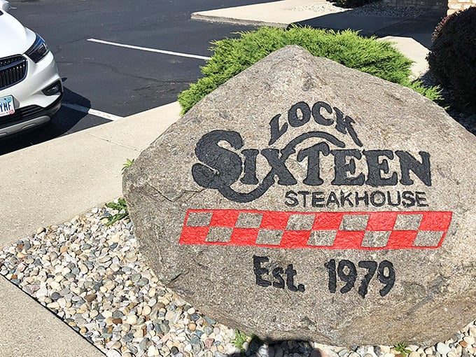 The boulder says it all – Lock Sixteen Steakhouse has been carving its reputation in stone since 1979, with that classic red-and-black checkered pattern promising comfort and satisfaction.