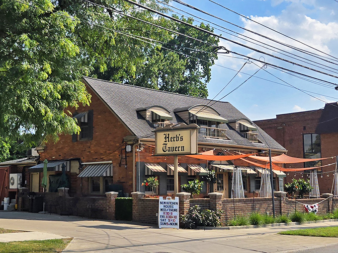 The brick facade and cheerful red umbrellas of Herb's Tavern beckon like an old friend saying, "Come on in, the comfort food's waiting."